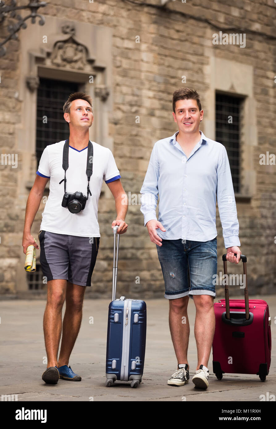 Cheerful tourists at summer vacation walking the street and smiling ...