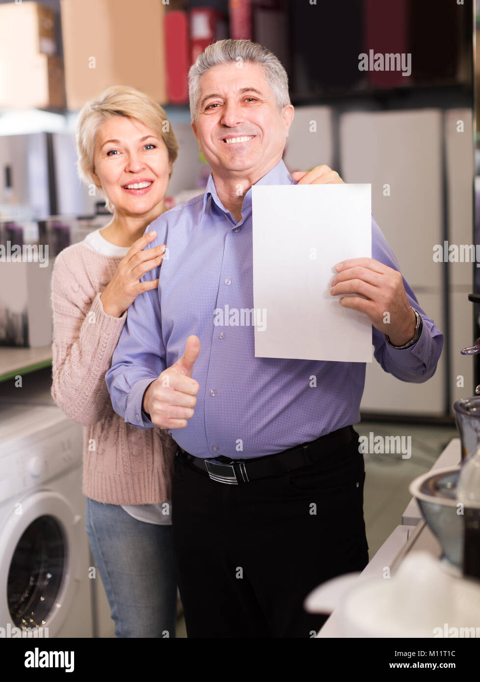 Husband and wife are buying in store on credit household appliances for ...