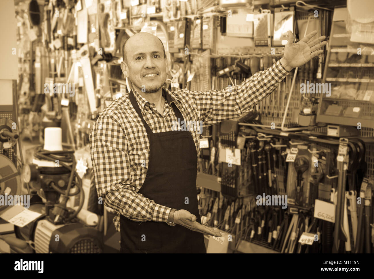 Smiling salesman showing different tools and instruments in wholesale ...