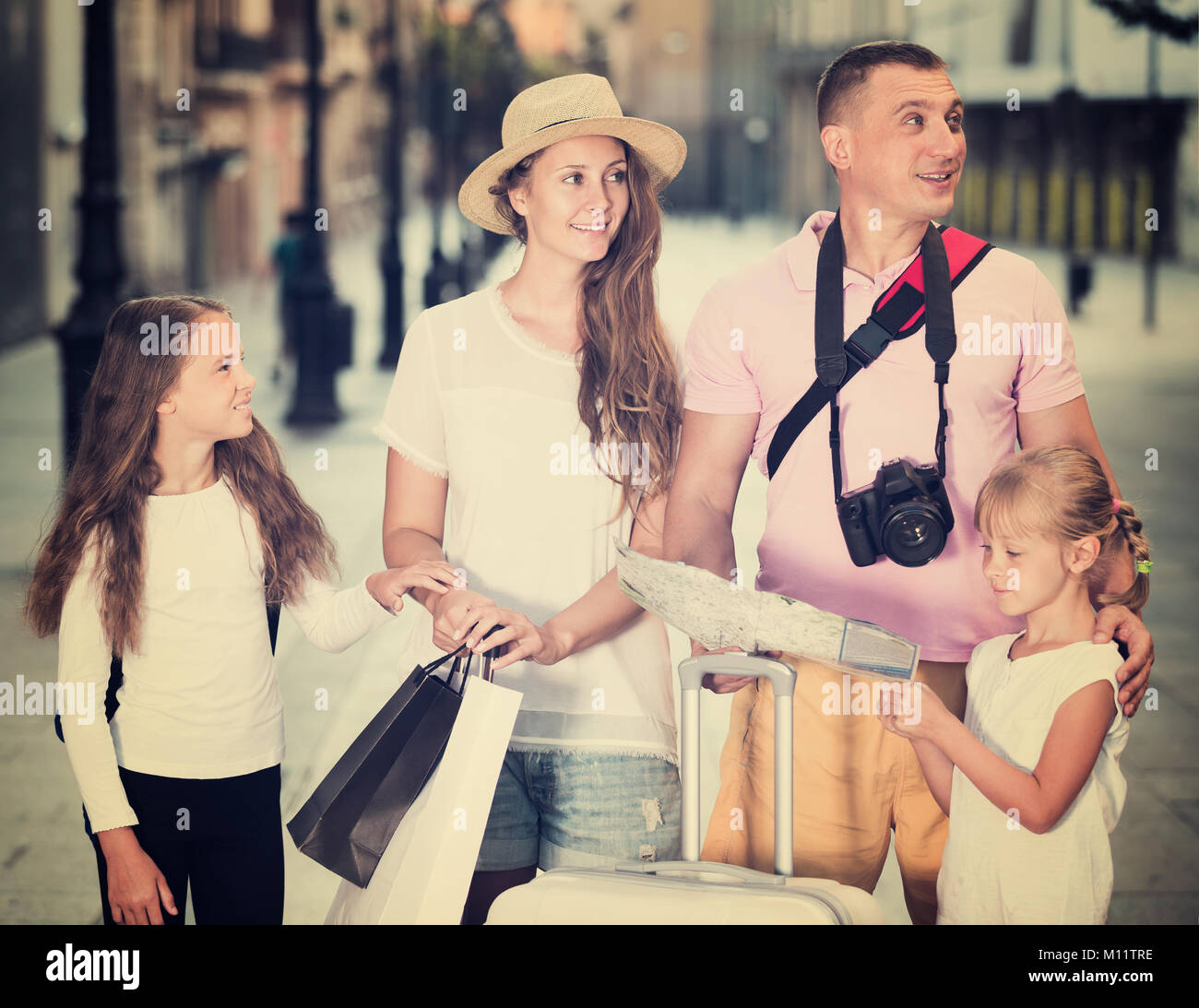 Family of tourists with two children looking for destination with city ...