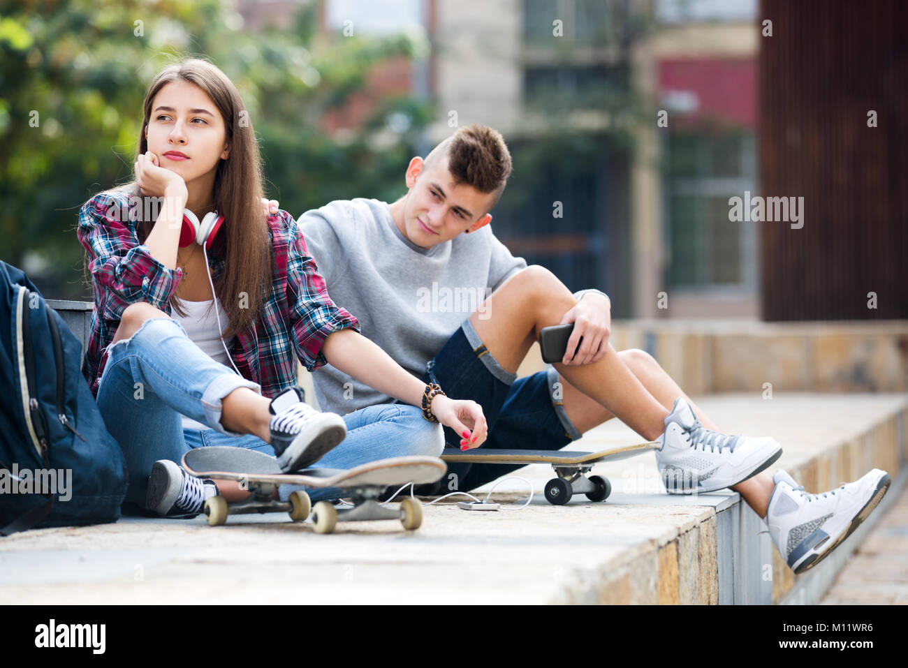 Young guy apologizes to her girlfriend after an argument outdoor. Focus ...