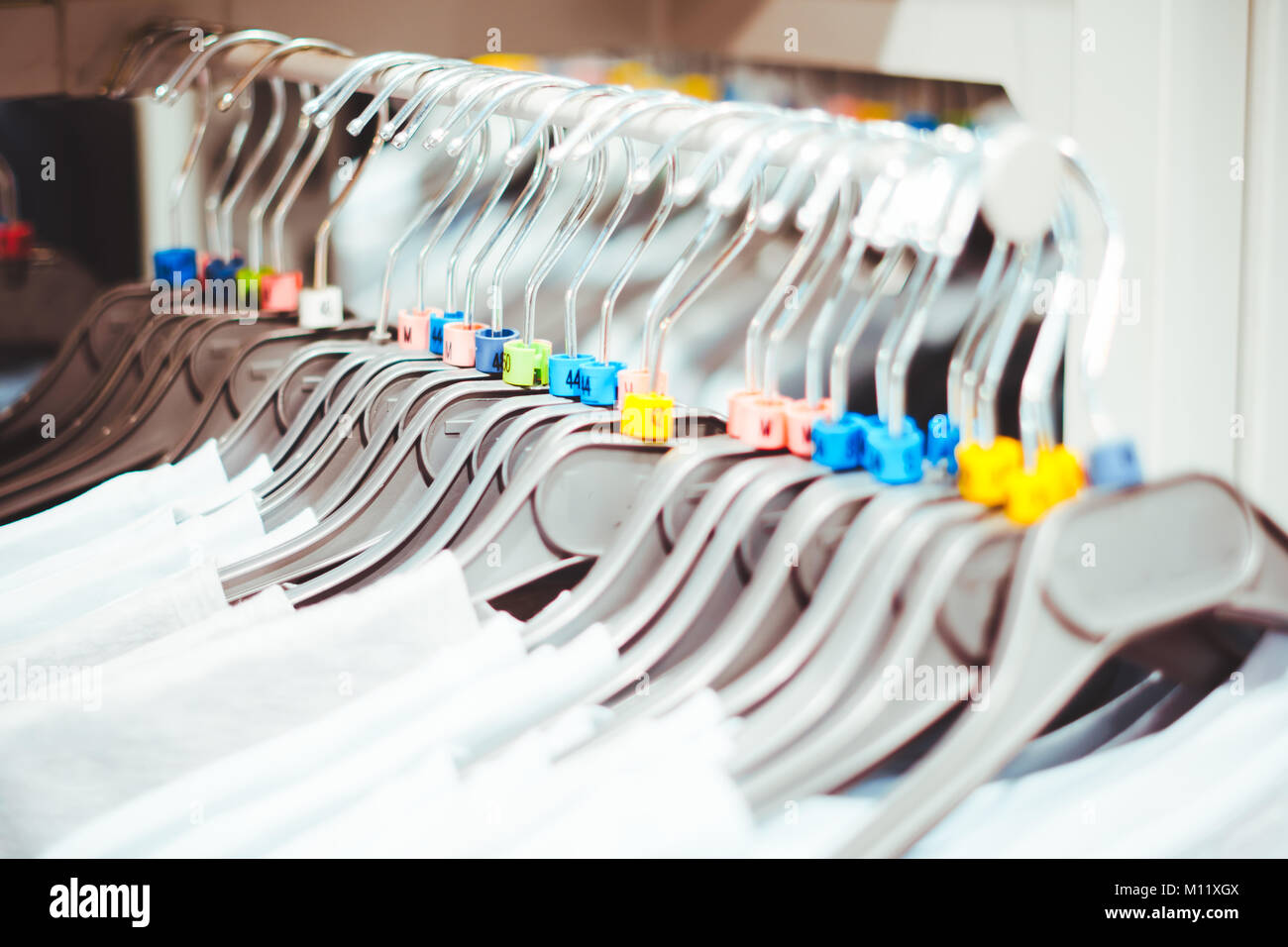 clothes hanger in the store hanging in a row Stock Photo - Alamy