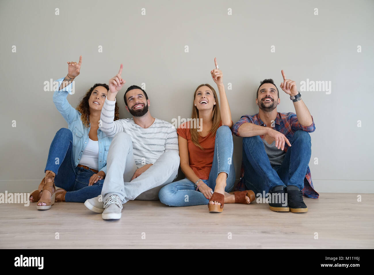 Friends pointing up at message, isolated Stock Photo - Alamy