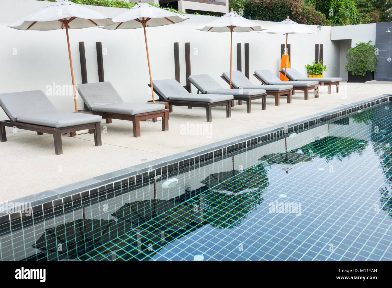 Beach chairs near swimming pool Stock Photo - Alamy