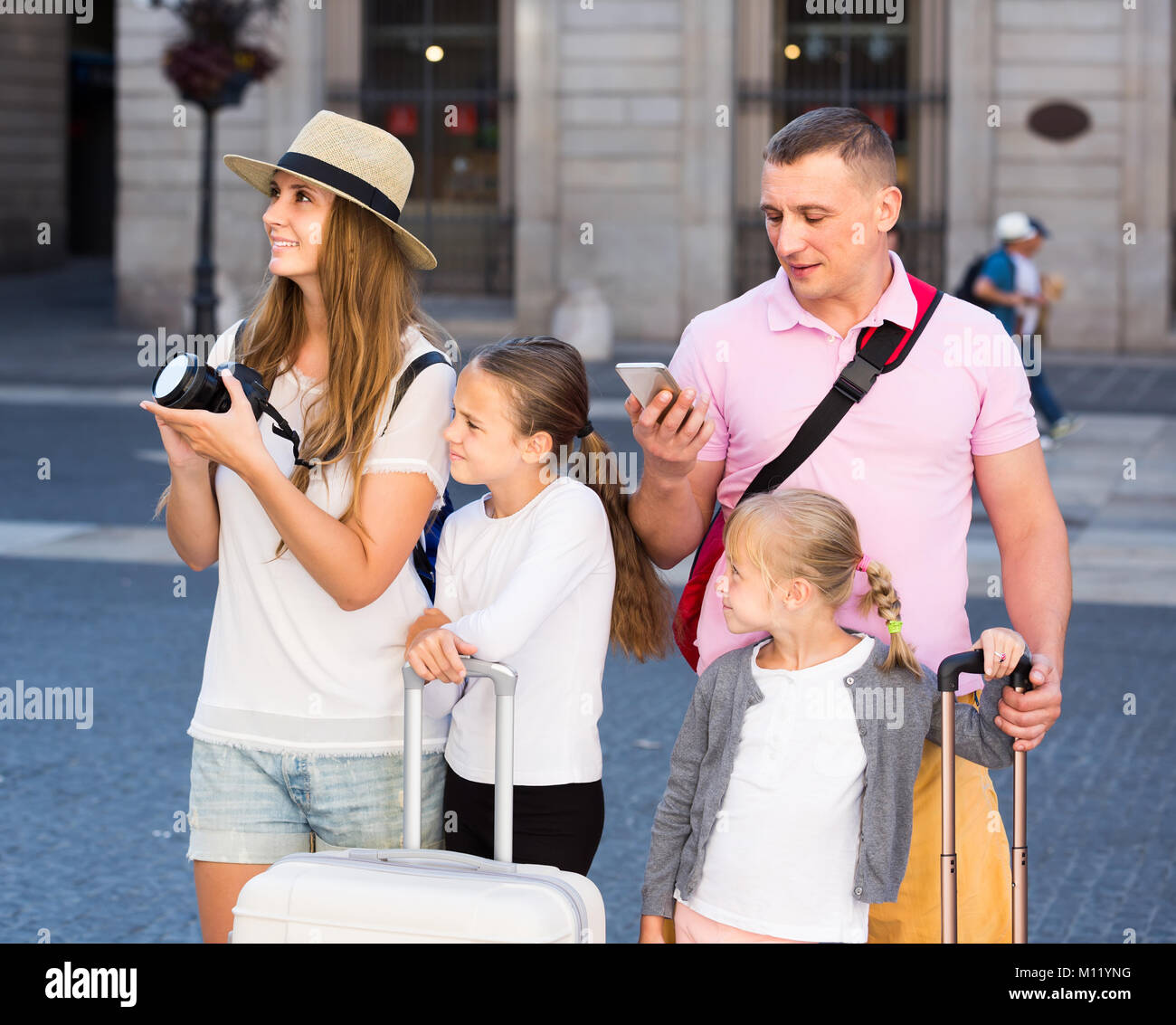 Cheerful russian parents with two kids using smartphone and ...