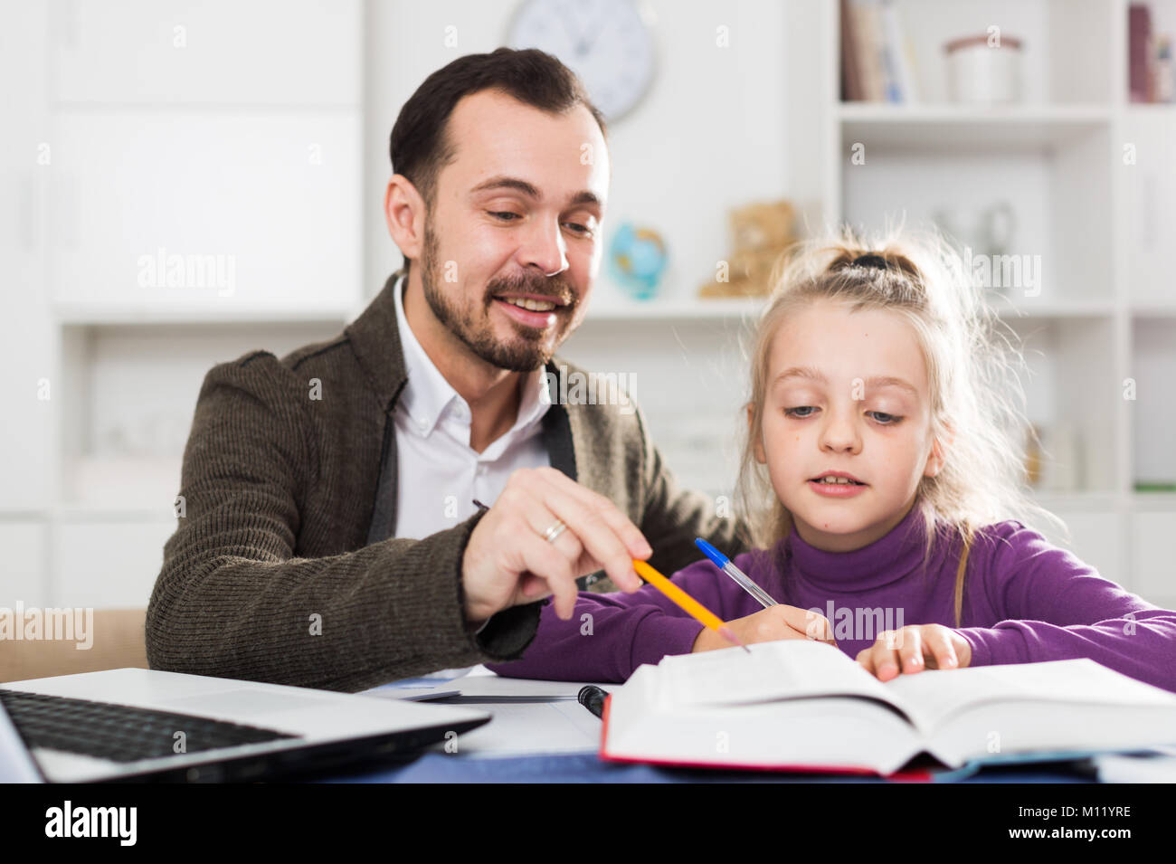 Young father explaining homework to his daughter at home Stock Photo ...