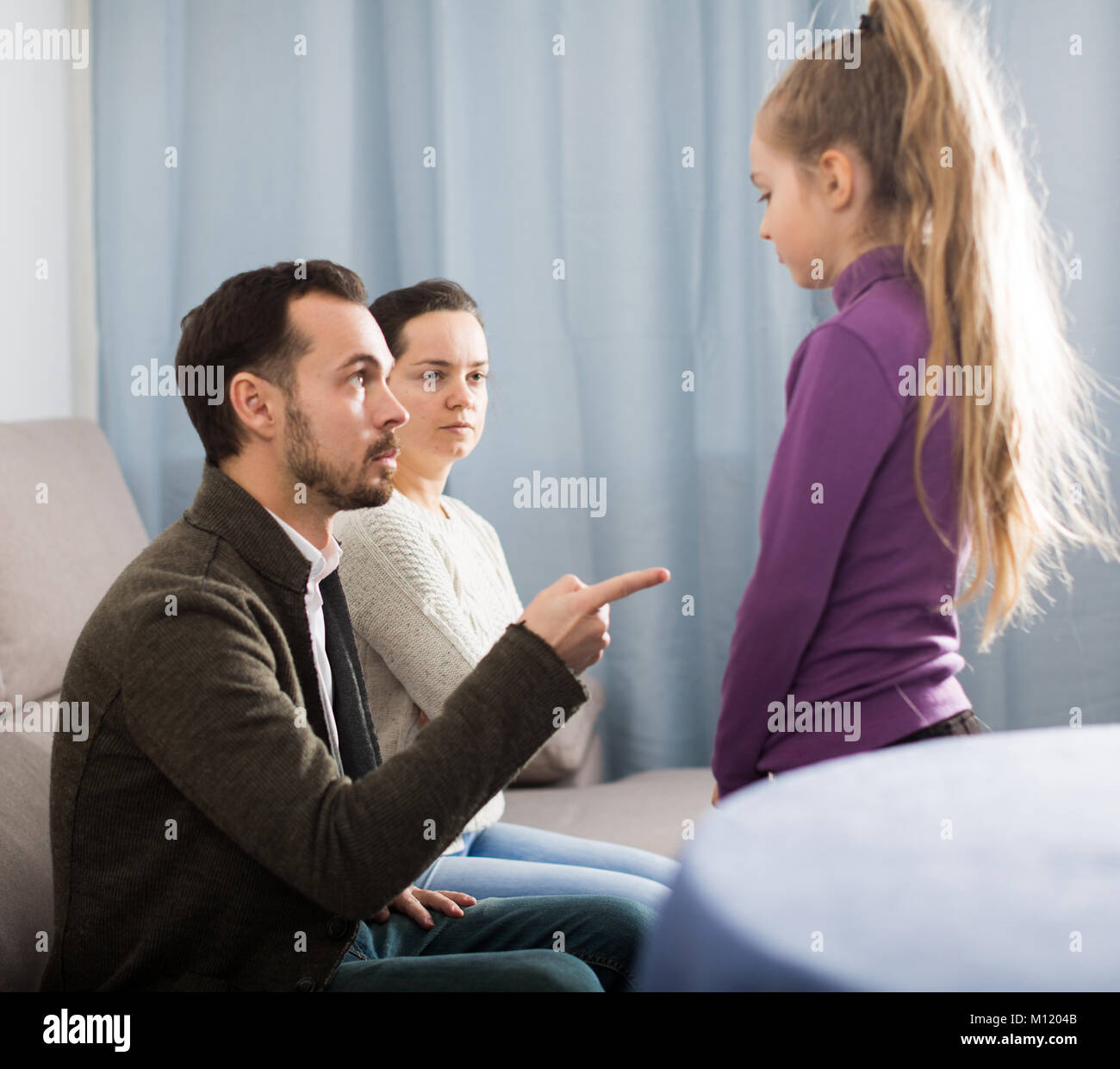 Young father and mother correcting their child for disobedience Stock ...