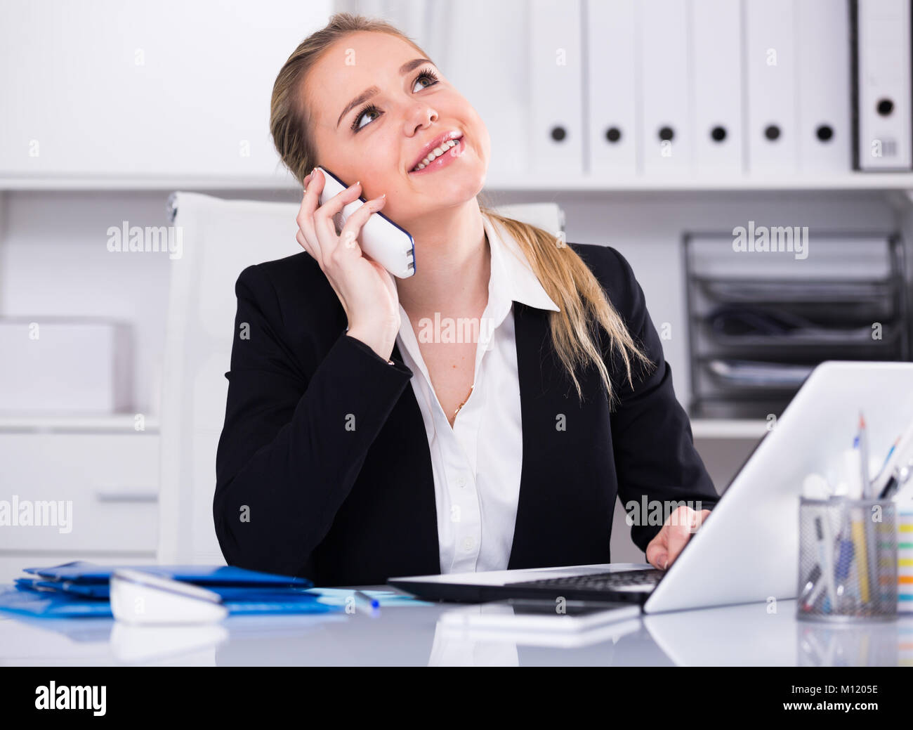 Young businesswoman having phone call conversation at workplace in ...