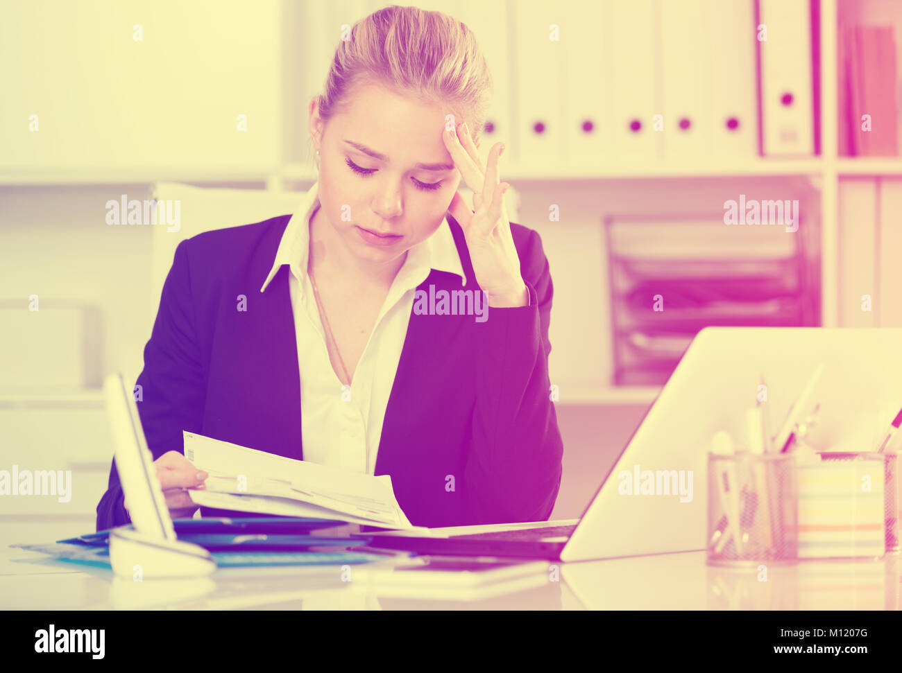 Frustrated business woman sitting at office desk with papers Stock Photo - Alamy