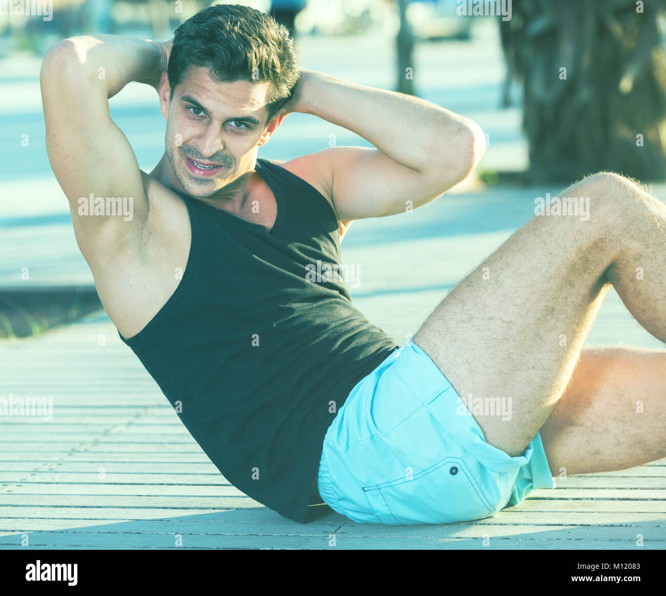 Fitness man doing abs crunches during daily outdoor workout Stock Photo ...