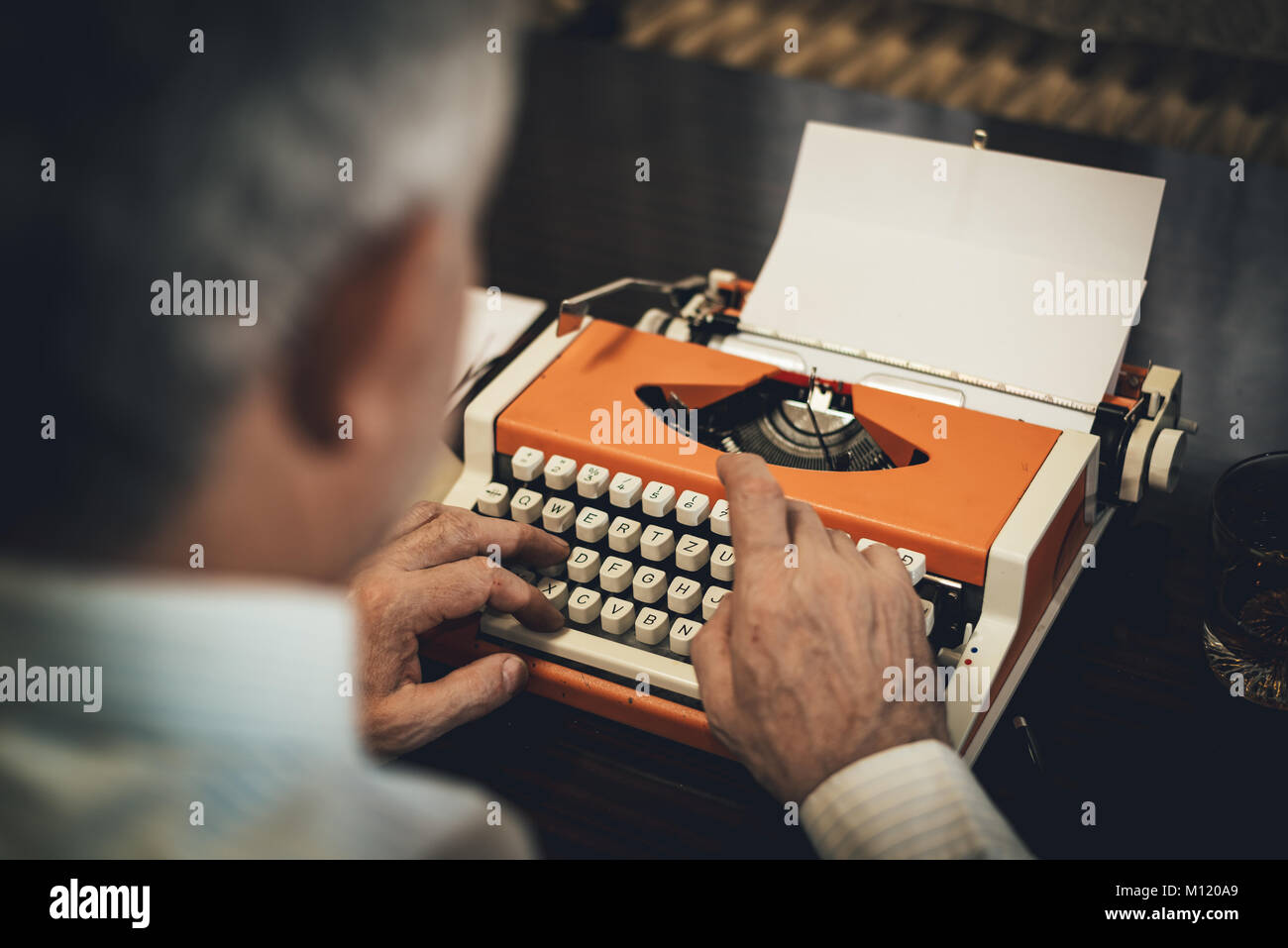 Rear view of a senior men's hands typing on obsolete typewriter Stock ...