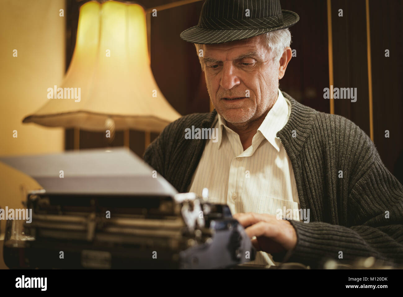 Retro senior man writer with hat, writing on obsolete typewriter Stock ...