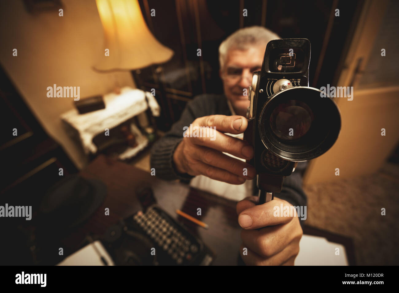 Senior man holding old fashioned movie camera. Selective focus Stock ...