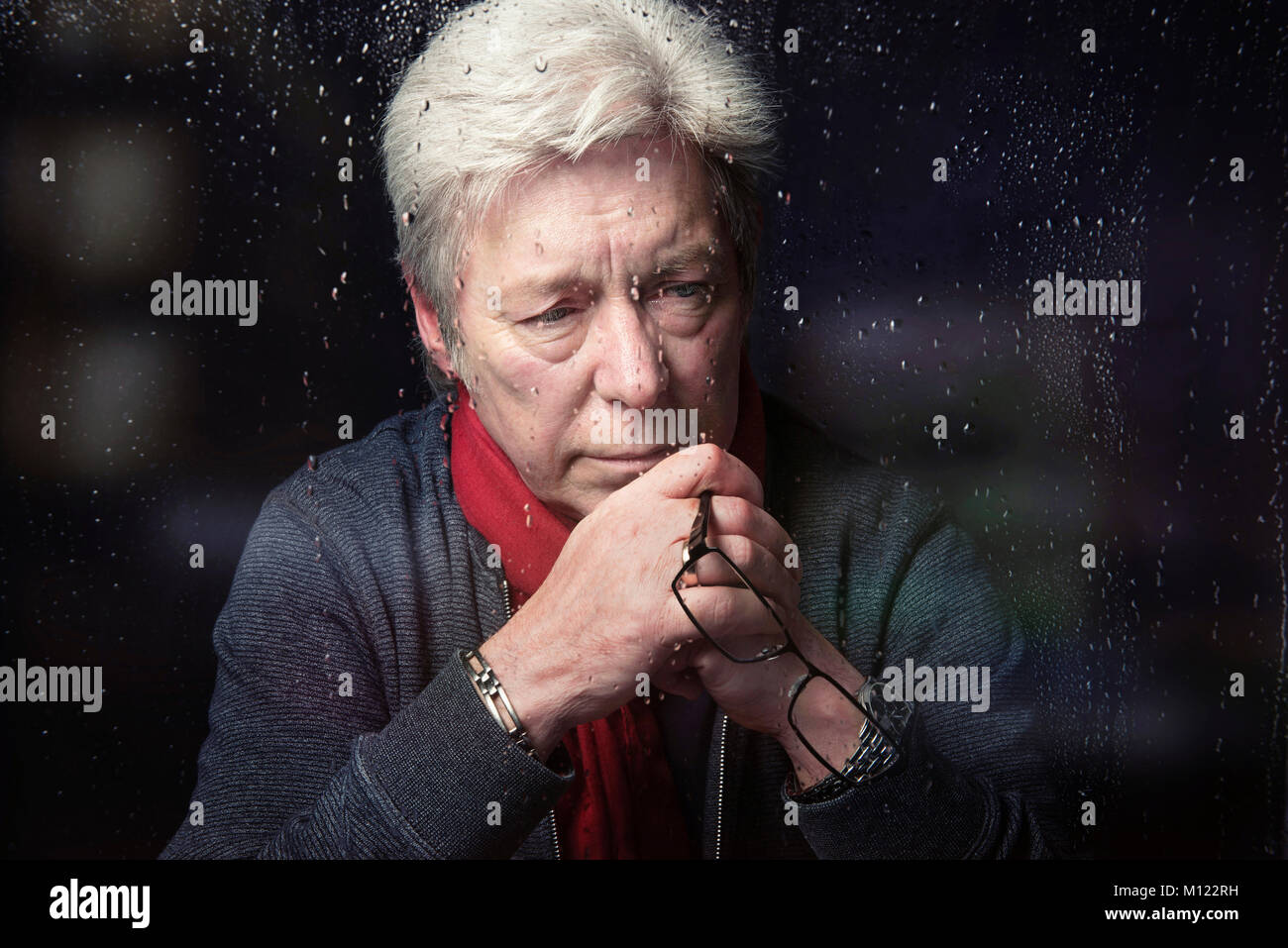 Depressed sad Man looking tearful holding glasses in front of face at ...