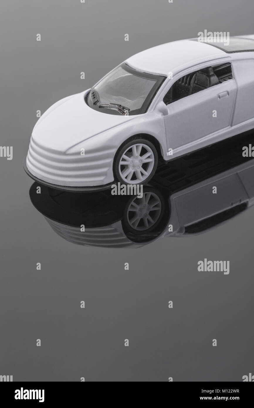 Small toy sports car / car toy on reflective surface - metaphor for ...