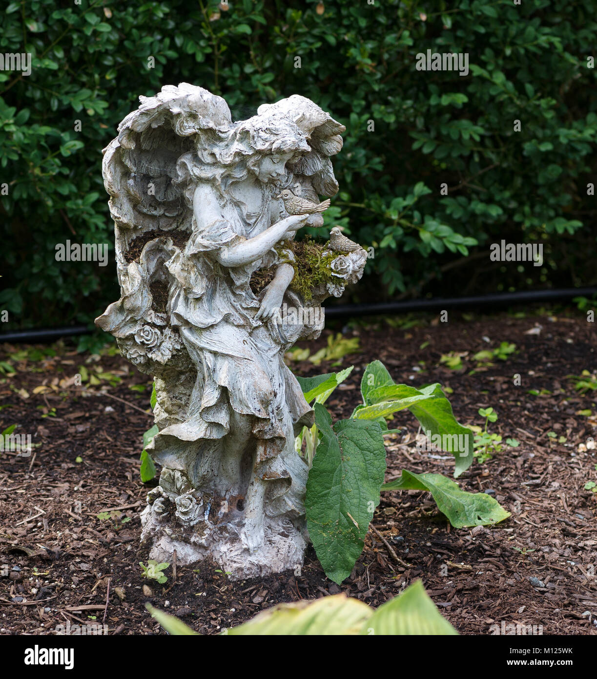 concrete statue of an angel with birds in a garden Stock Photo - Alamy