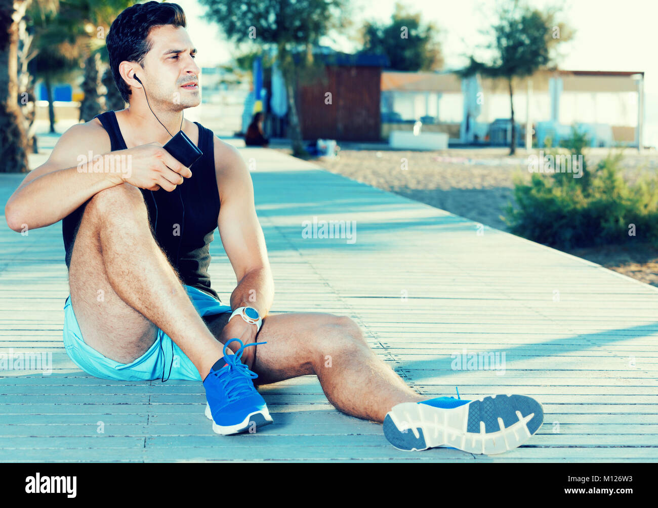 Smiling cheerful positive sporty man resting after workout on ...