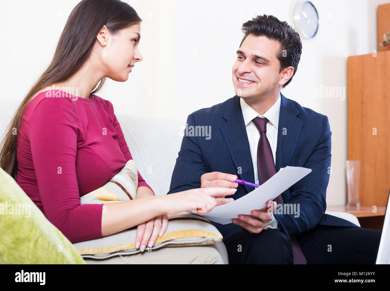 Banking agent showing contract to female client in domestic interior ...
