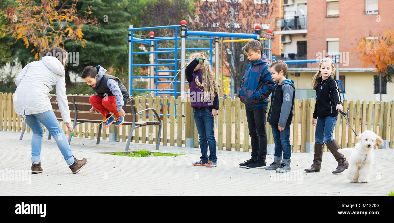 smiling european children playing rubber band jumping game and laughing ...