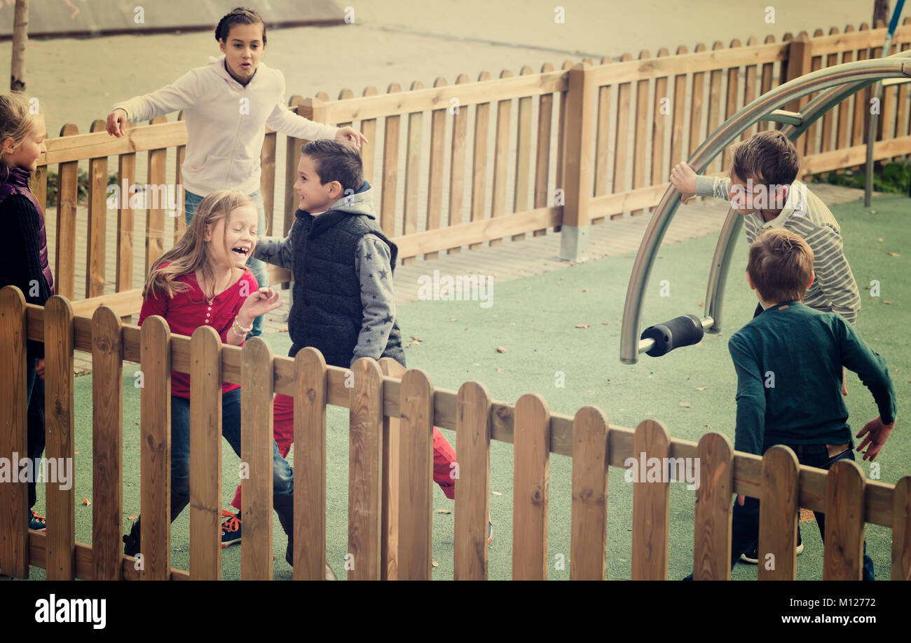 Positive kids running around while playing at Tag in street Stock Photo ...