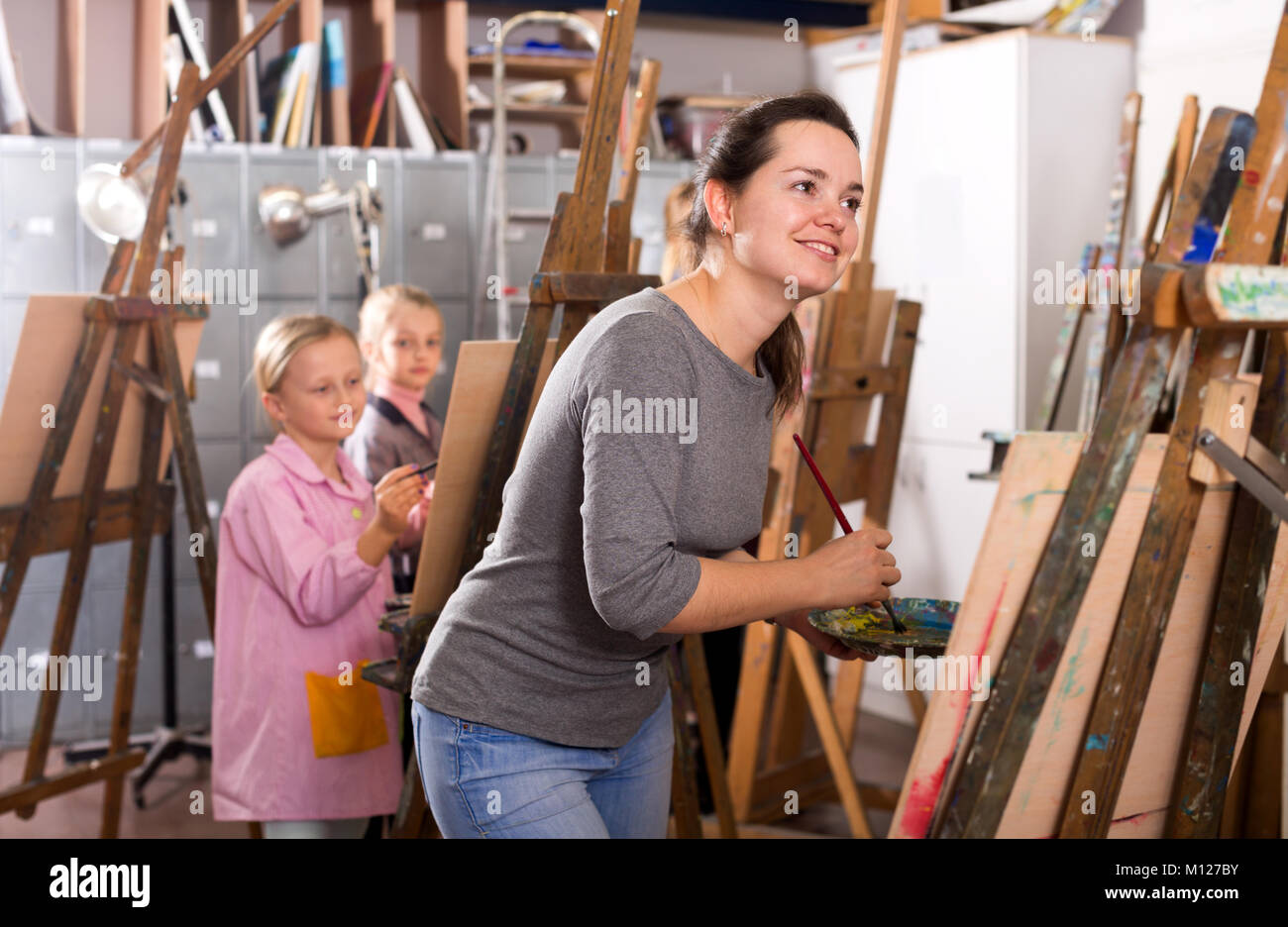 Happy young female students practicing their skills during painting ...