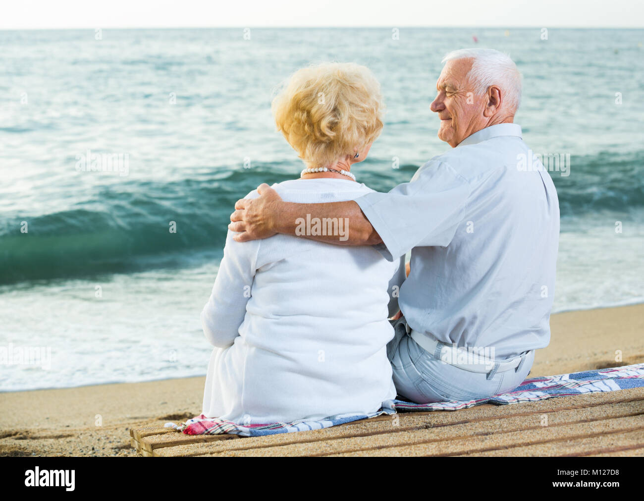 Portrait of mature female and male back hugging on the beach Stock ...