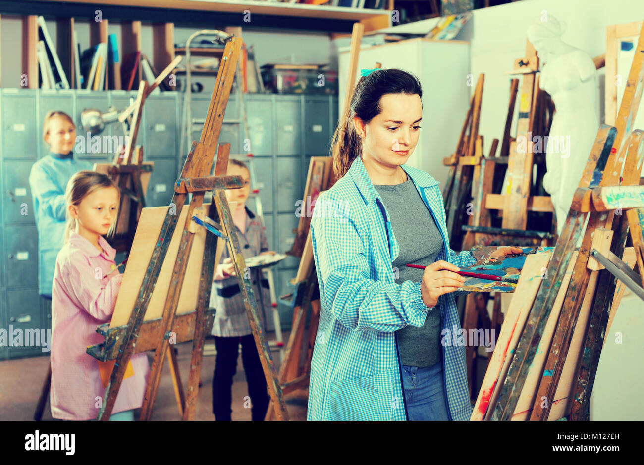 Skillful cheerful positive students working patiently during painting ...