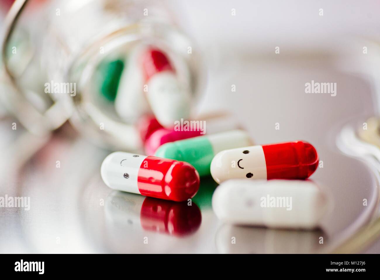 Capsule pills with smile on reflective surface Stock Photo - Alamy