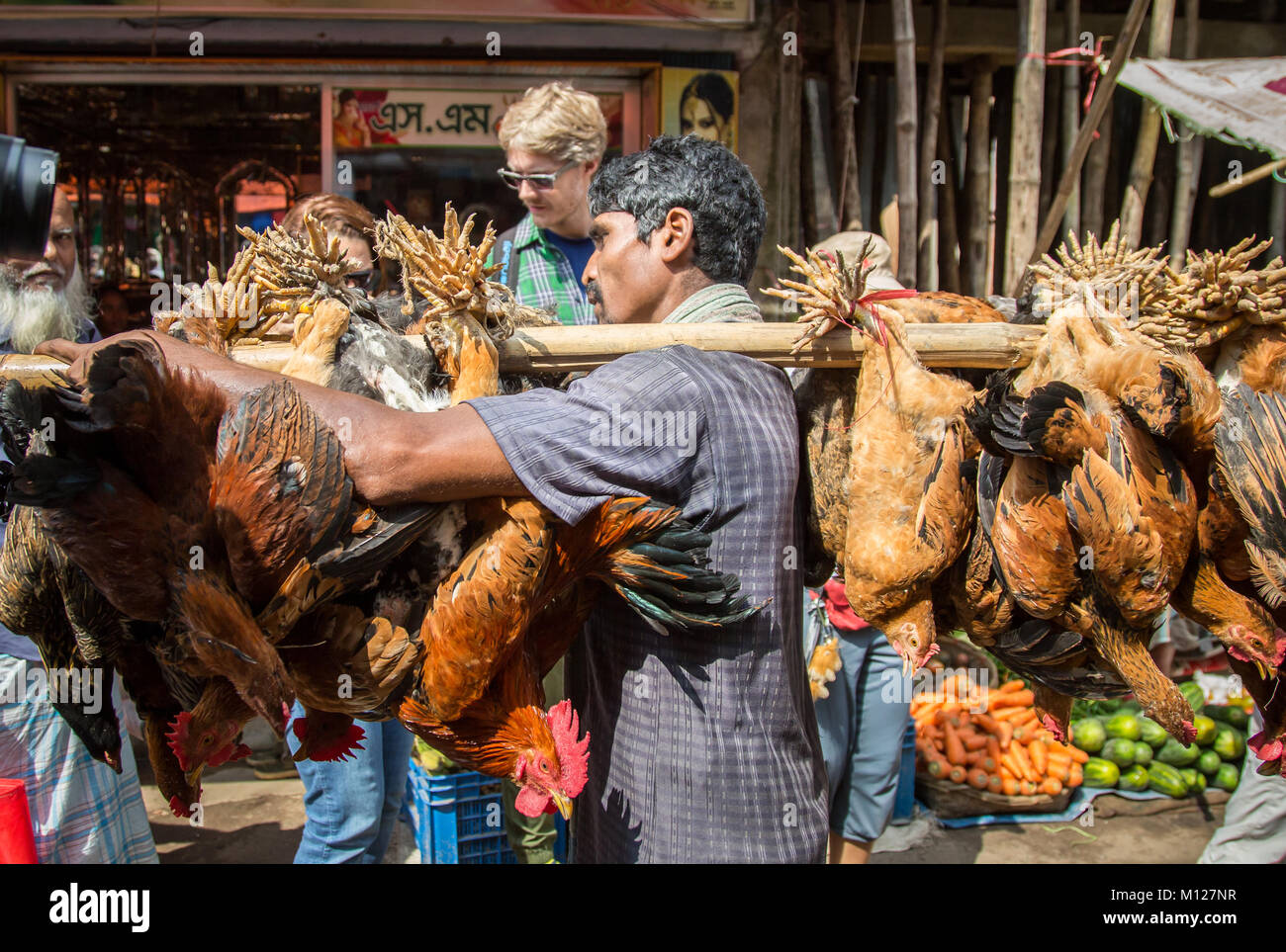 man carrying chickens at a market Stock Photo - Alamy