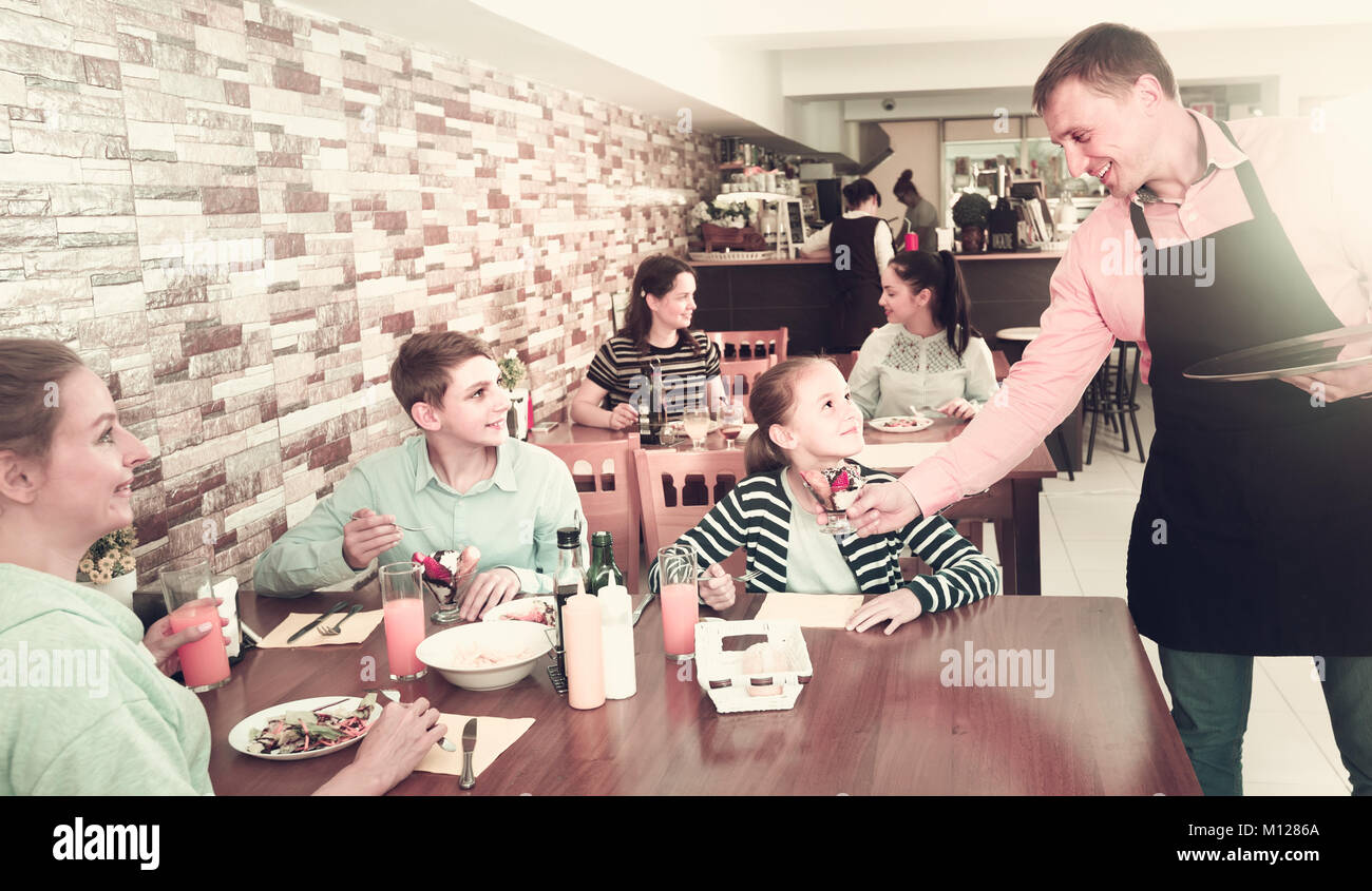 happy american waiter warmly welcoming guests to cozy family cafe Stock ...
