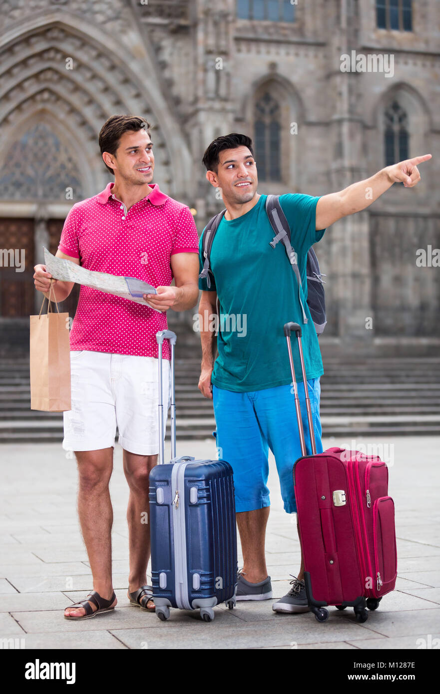 Men tourists are watching in map and searching way for walking in the ...