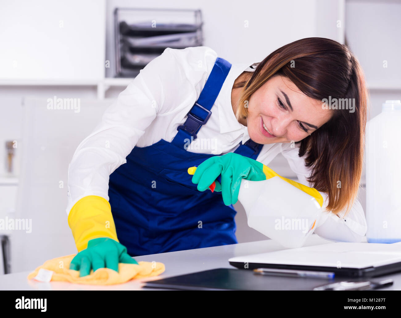 Female cleaning employee having a productive day in office Stock Photo ...