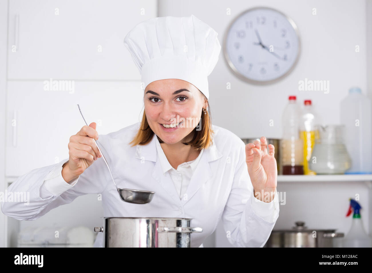 Smiling woman cook tasting delicious dishes in kitchen Stock Photo - Alamy