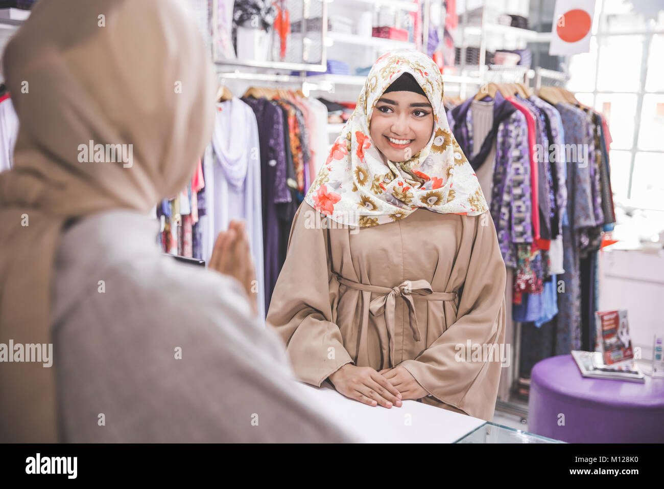 happy female cashier worker greeting customer in fashion store Stock ...