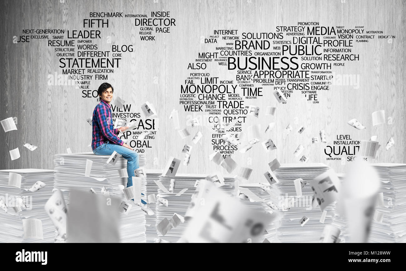 Attractive man sitting on pile of paper documents Stock Photo - Alamy