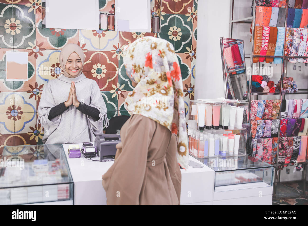 happy female cashier worker greeting customer in fashion store Stock ...