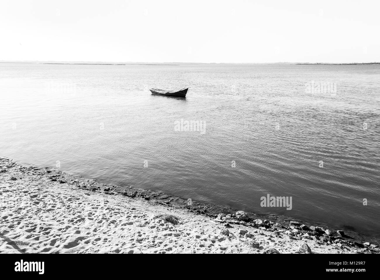 Isolated empty boat standing still over the sea. Black and white scene ...