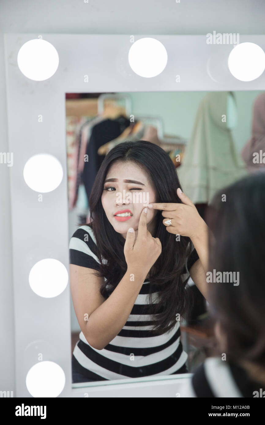 Acne treatment. Acne woman. Young woman squeezing her pimple, removing ...