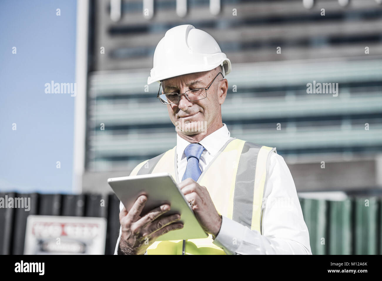Construction manager controlling building site and tablet device Stock ...