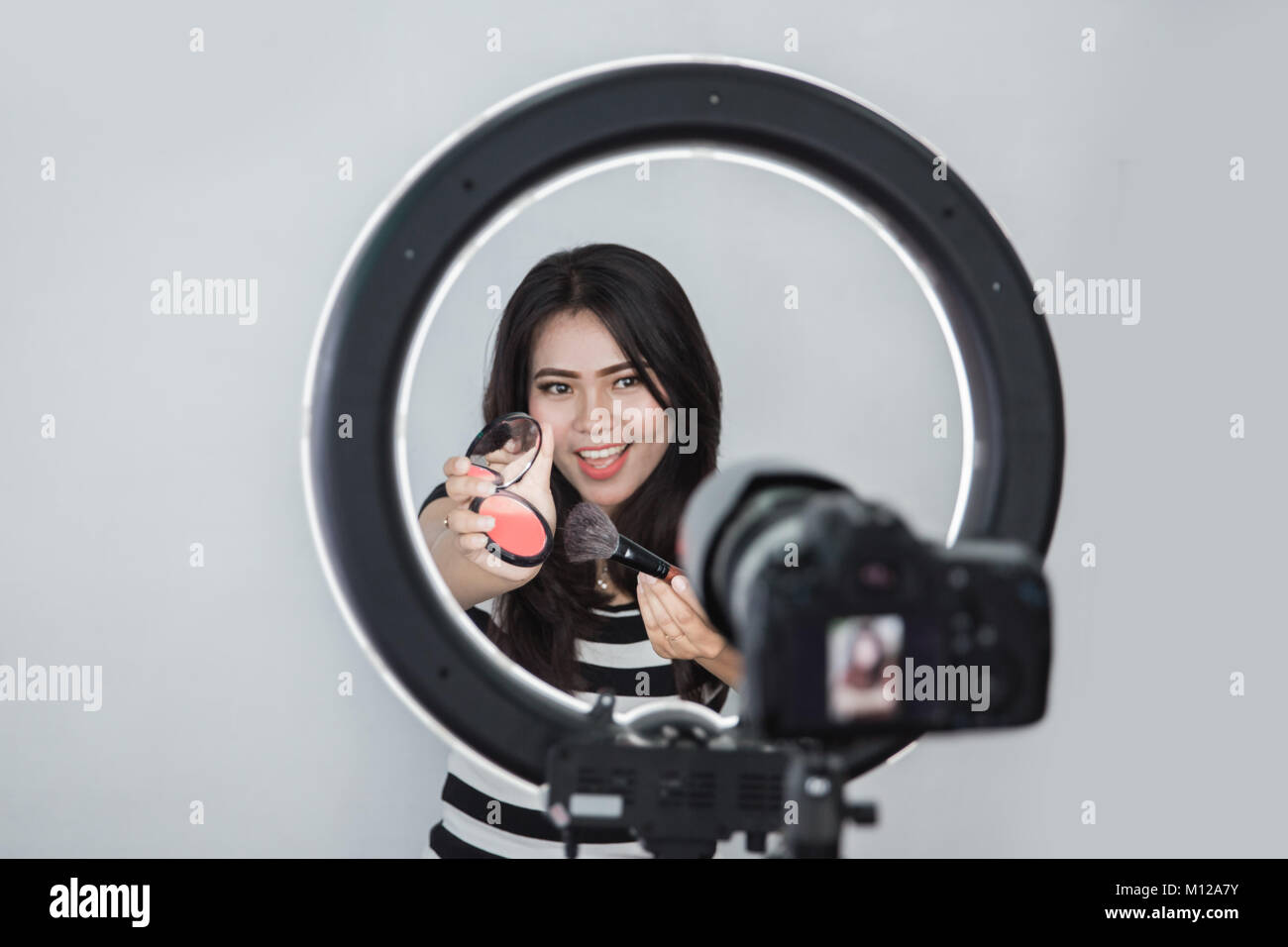 beauty blogger. makeup tutorial. video blog concept. portrait of asian woman showing makeup ...