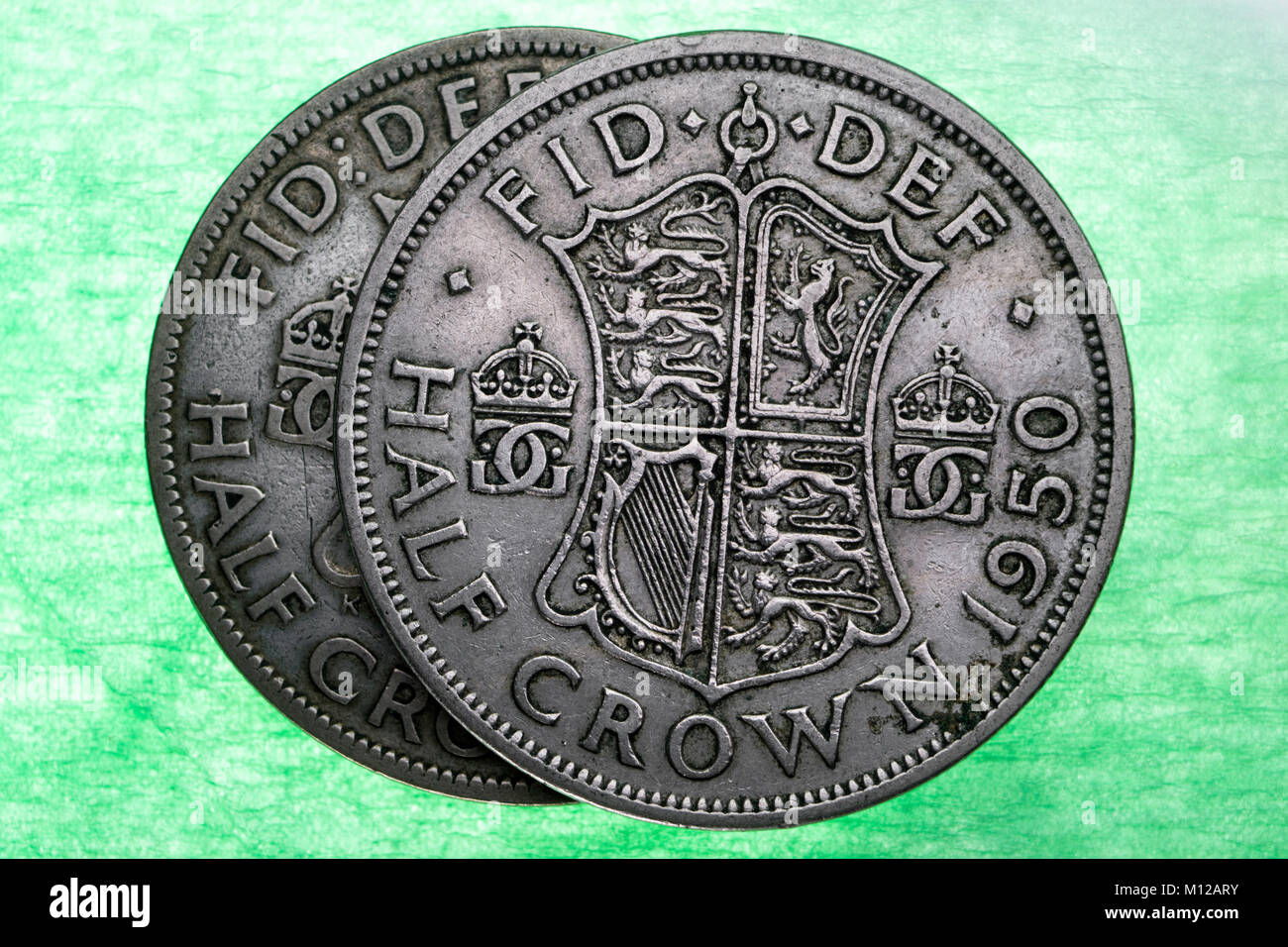 British Half Crown coins, top lit on a green illuminated background ...