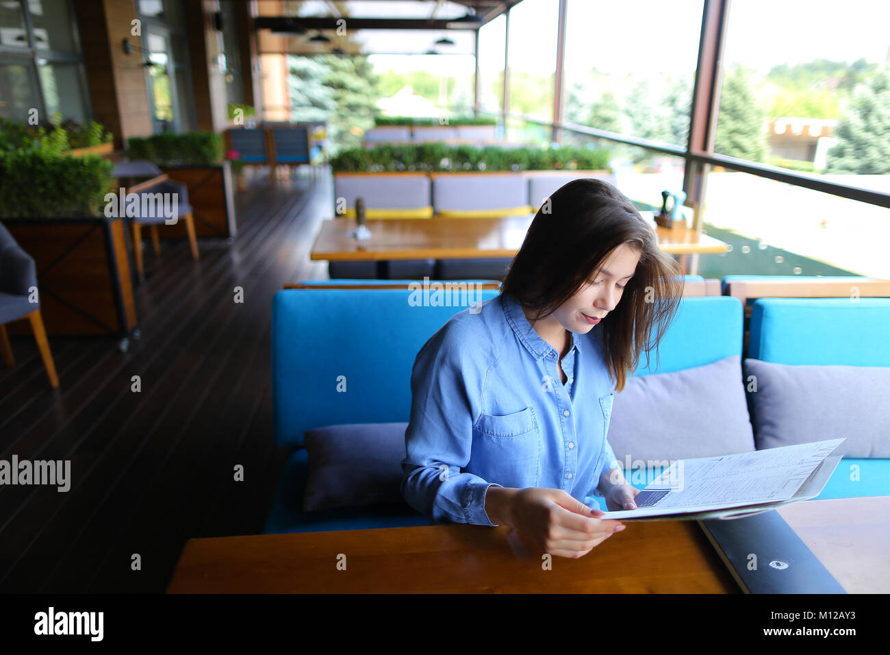 Beautiful lady reading menu at cafe Stock Photo - Alamy