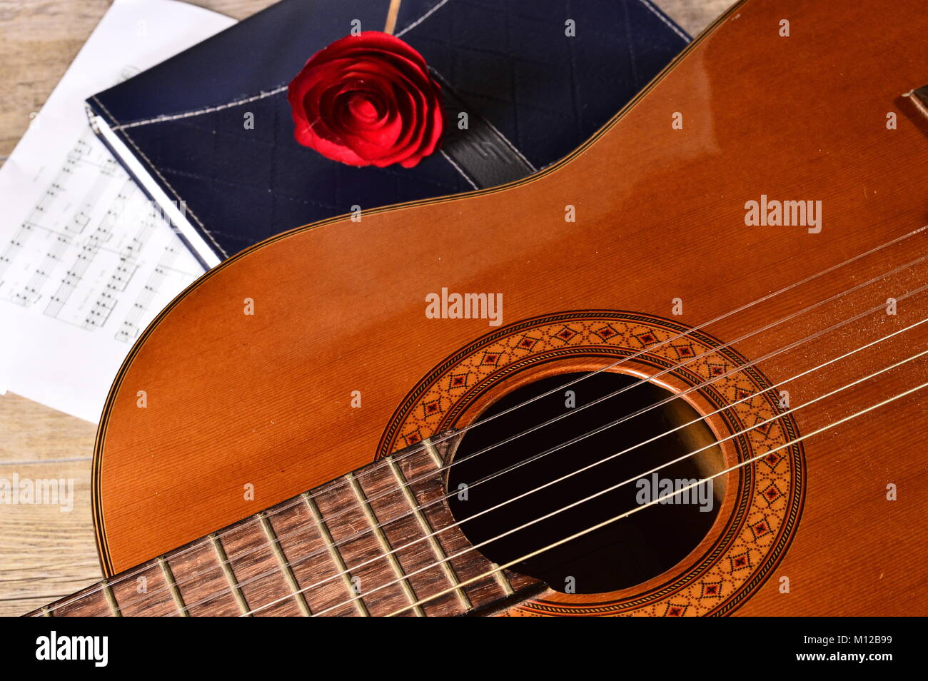 Guitar with a rose and sheet music Stock Photo - Alamy