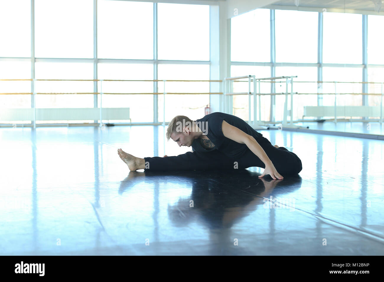 Dancer making leg stretching at gym Stock Photo - Alamy