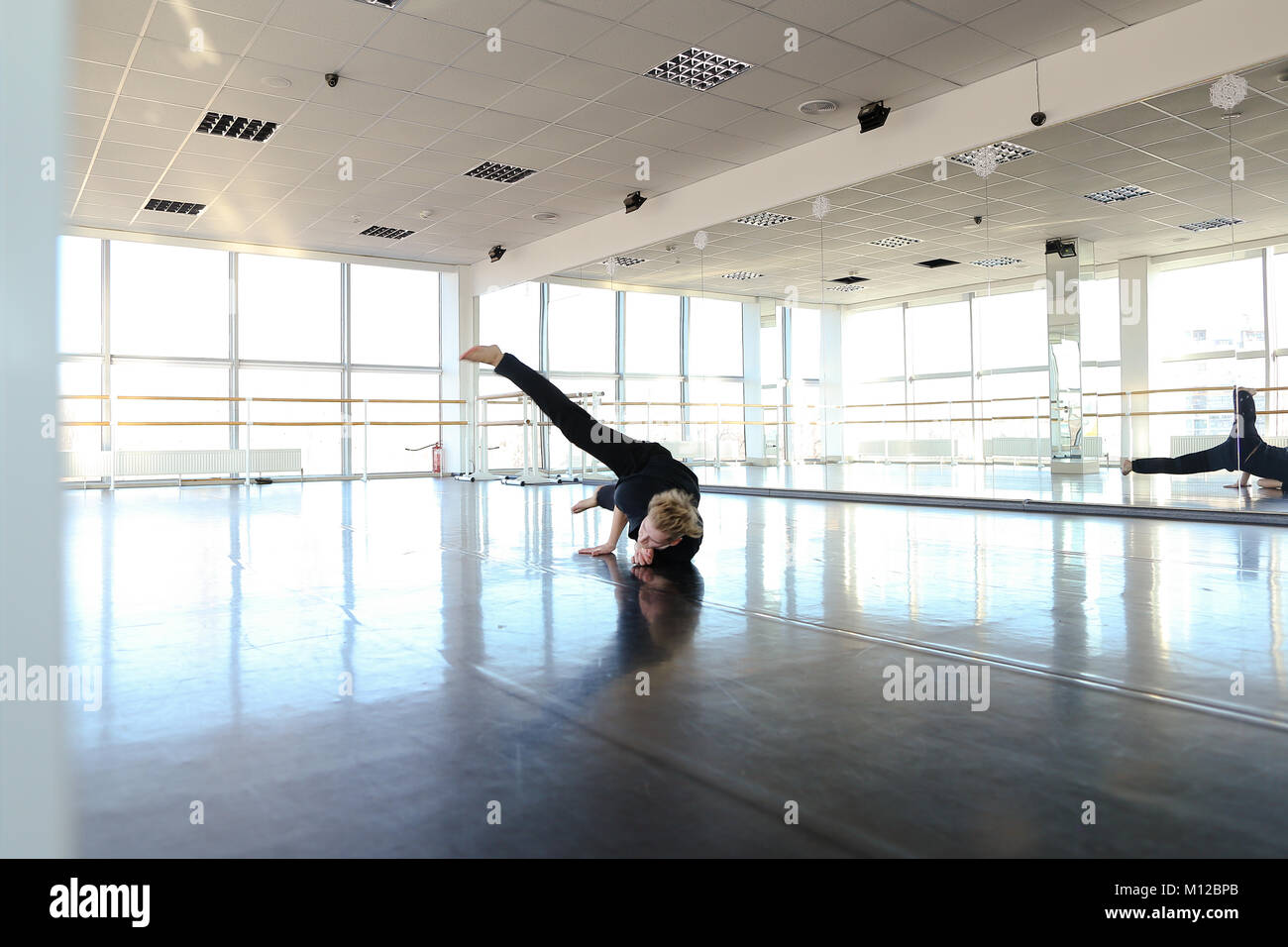 Dancer making leg stretching at gym Stock Photo - Alamy