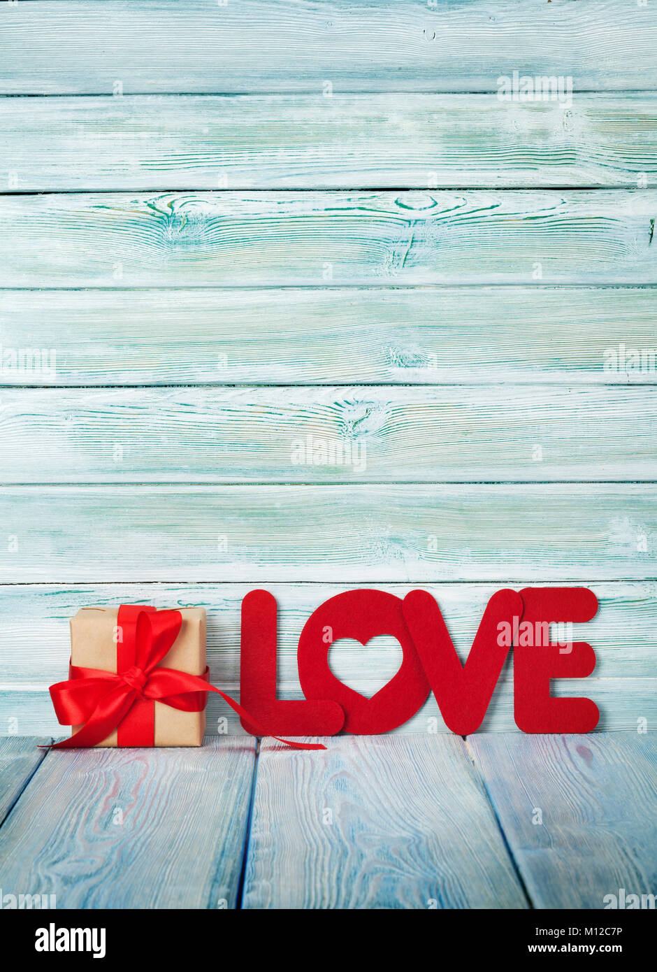 Valentines day greeting card with love word and gift box over wooden ...