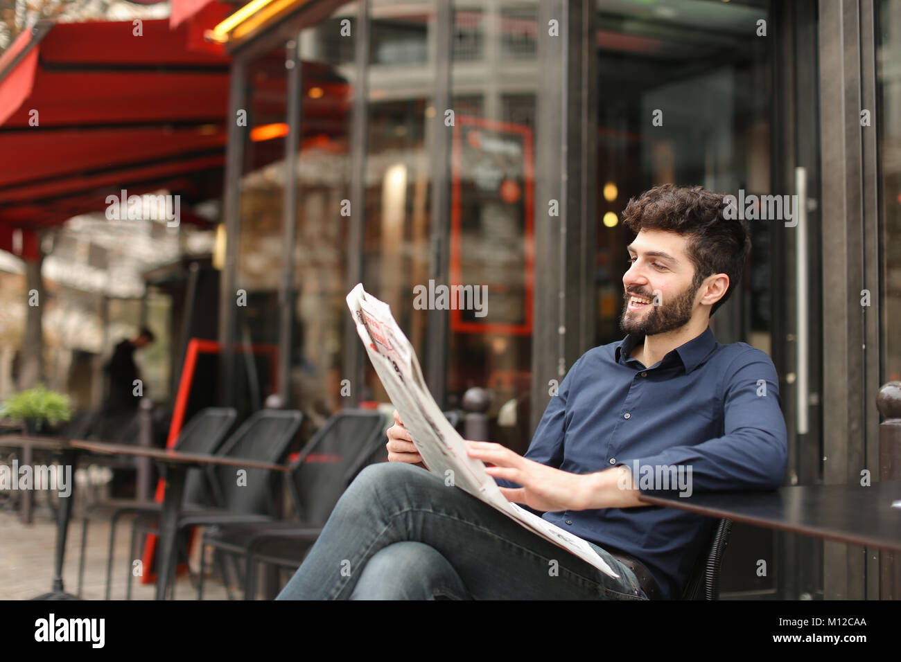 Journalist with close up face reading newspaper article at cafe Stock ...