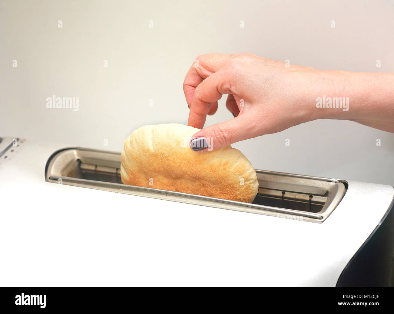 Female hand taking from toaster hot browned toast Stock Photo - Alamy
