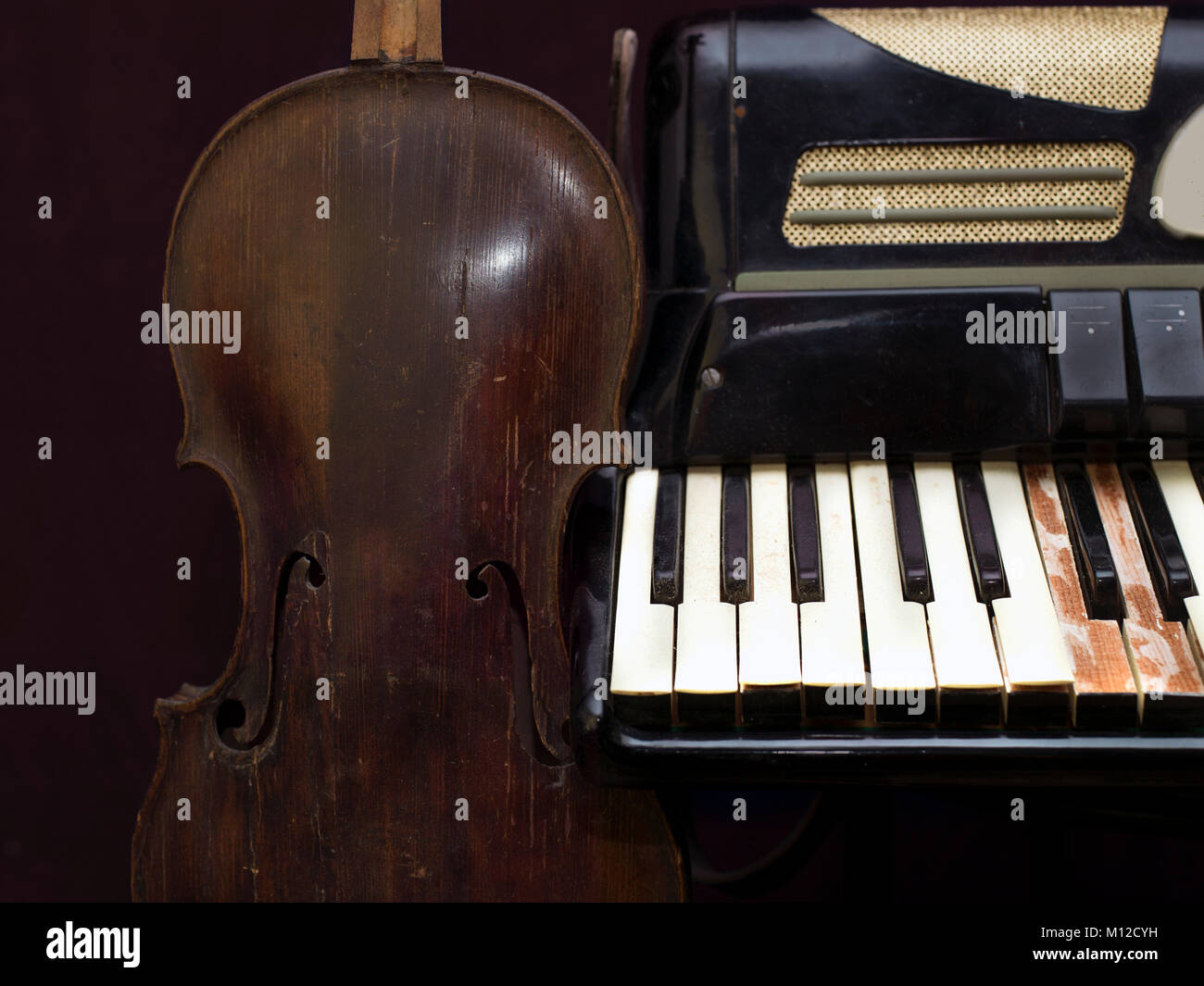 Front cropped shot of a violin without strings and broken harmonica ...
