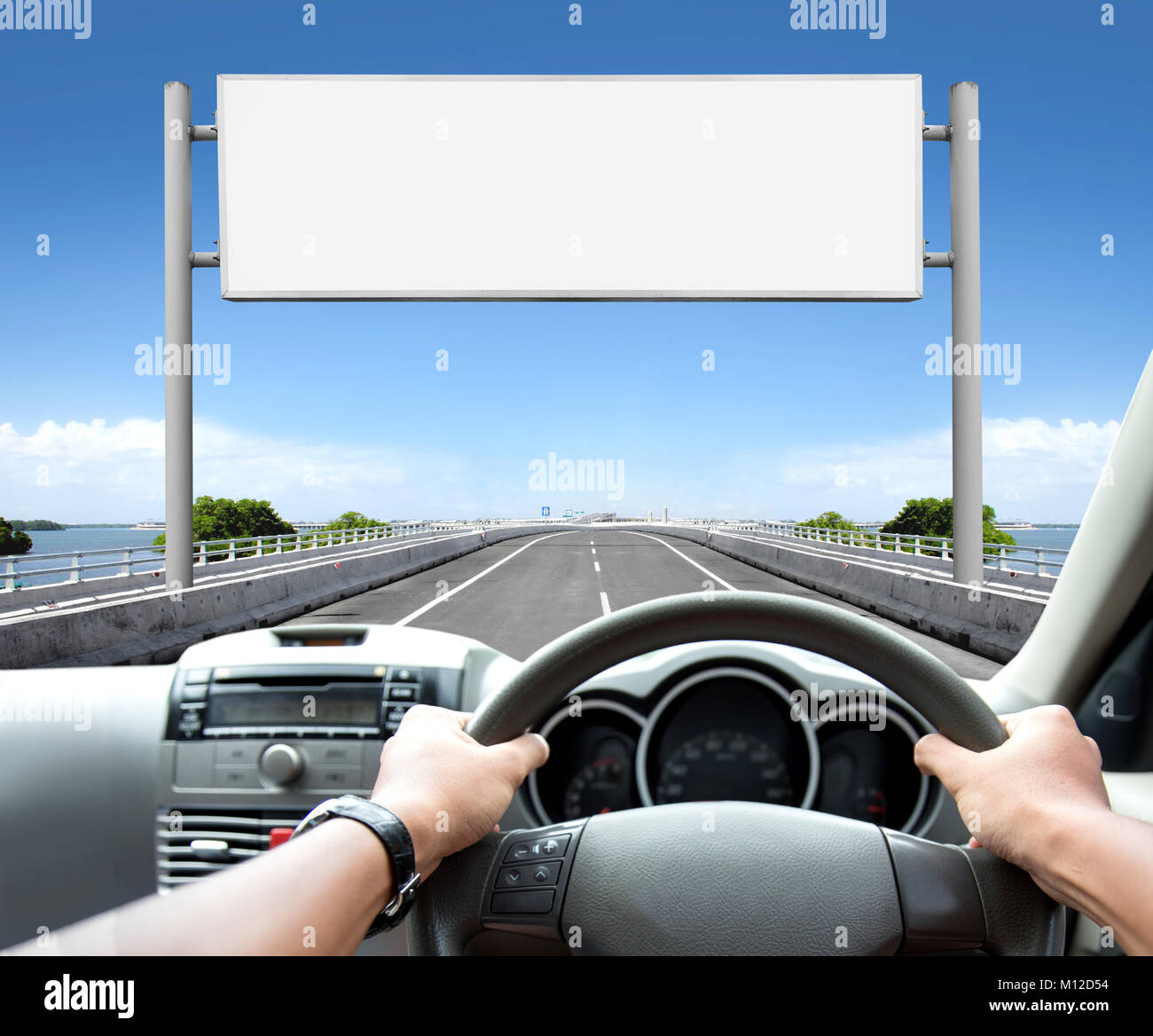 Man driving a car while looking at billboard or road sign ahead Stock ...